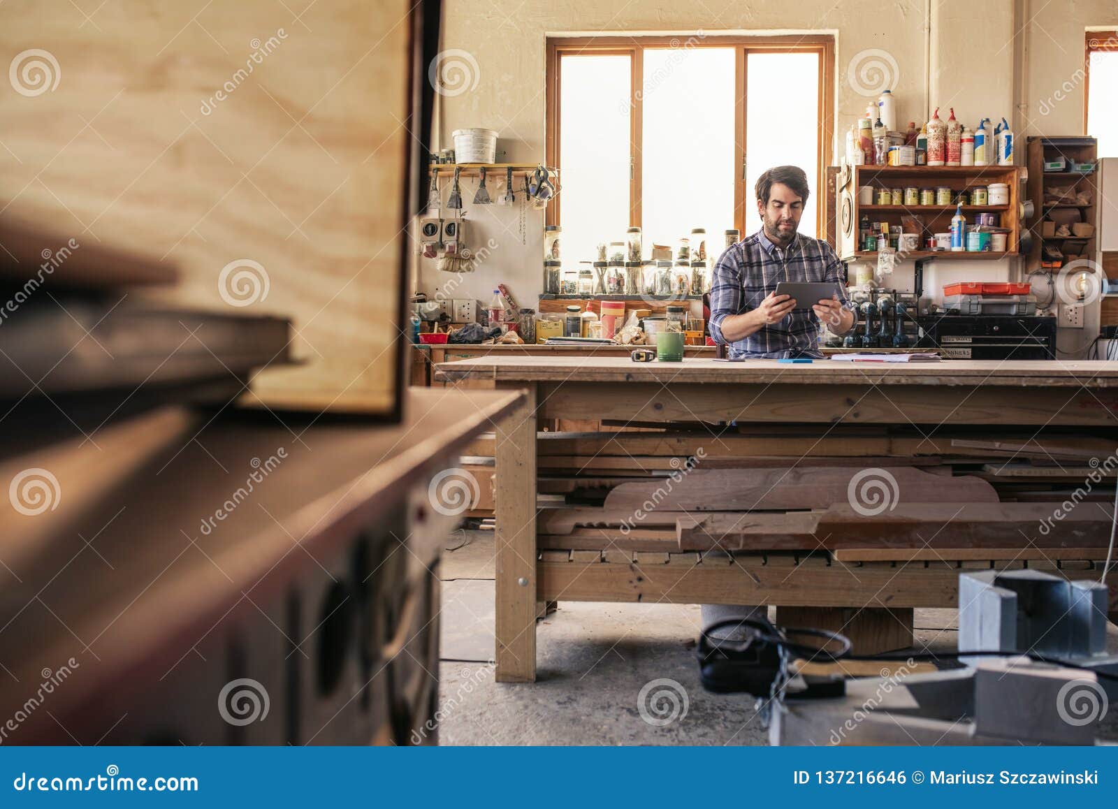 Woodworker Using a Tablet while Sitting at His Workbench Stock Photo ...