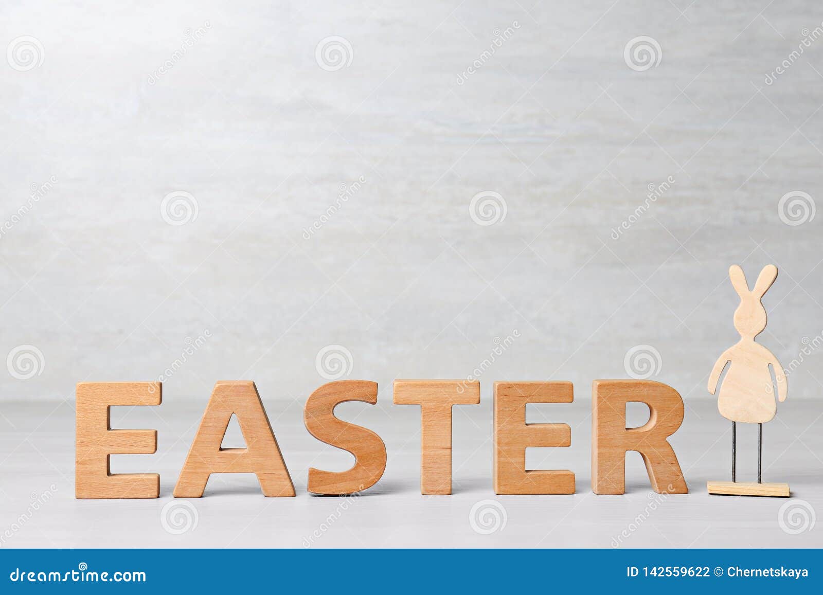 Word EASTER Made of Wooden Letters and Decorative Bunny on Table Stock ...