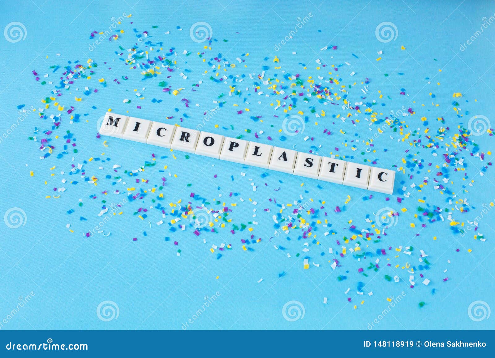 Word MICROPLASTIC Around Small Plastic Particles on a Blue Background ...