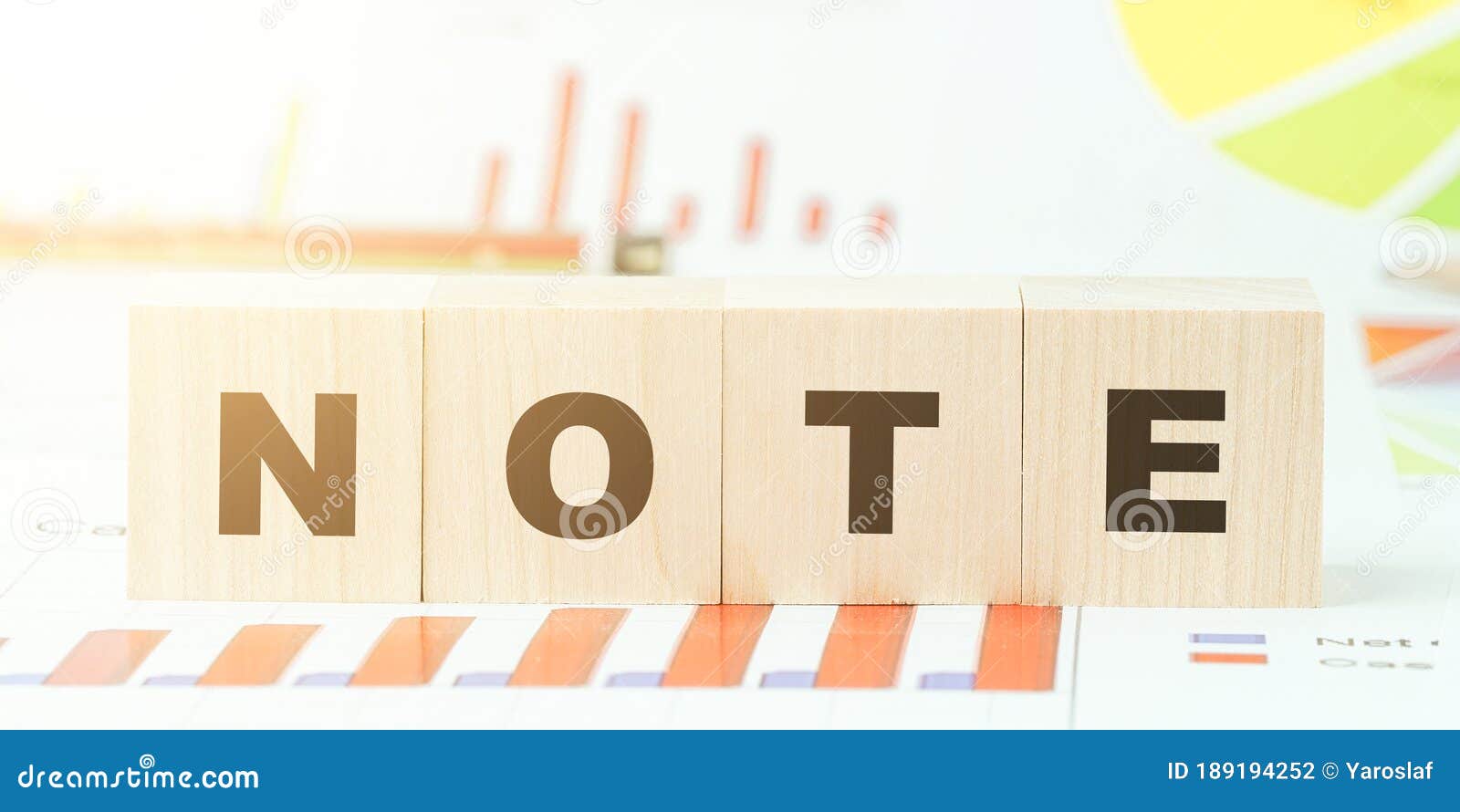 Word Note with Letters on Wooden Cubes on Table with Graphs Stock Photo ...