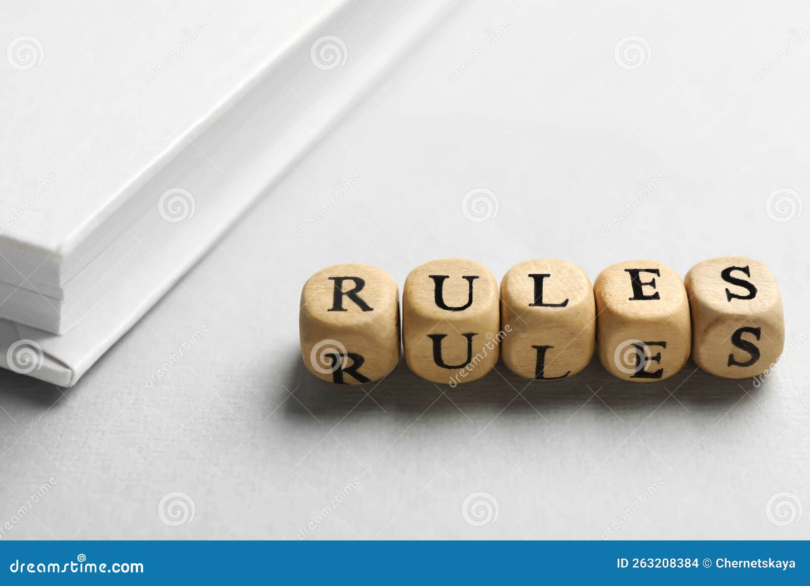 Word Rules Made of Wooden Cubes with Letters and Book on White Table ...