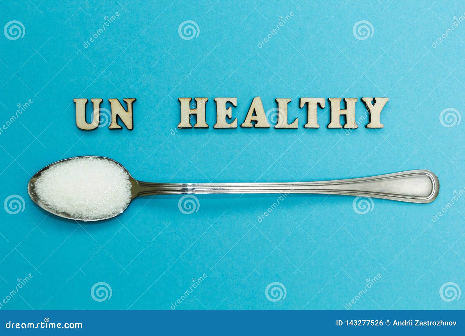 The Word `un Healthy`, a Spoon with Sugar on a Blue Background, Concept ...