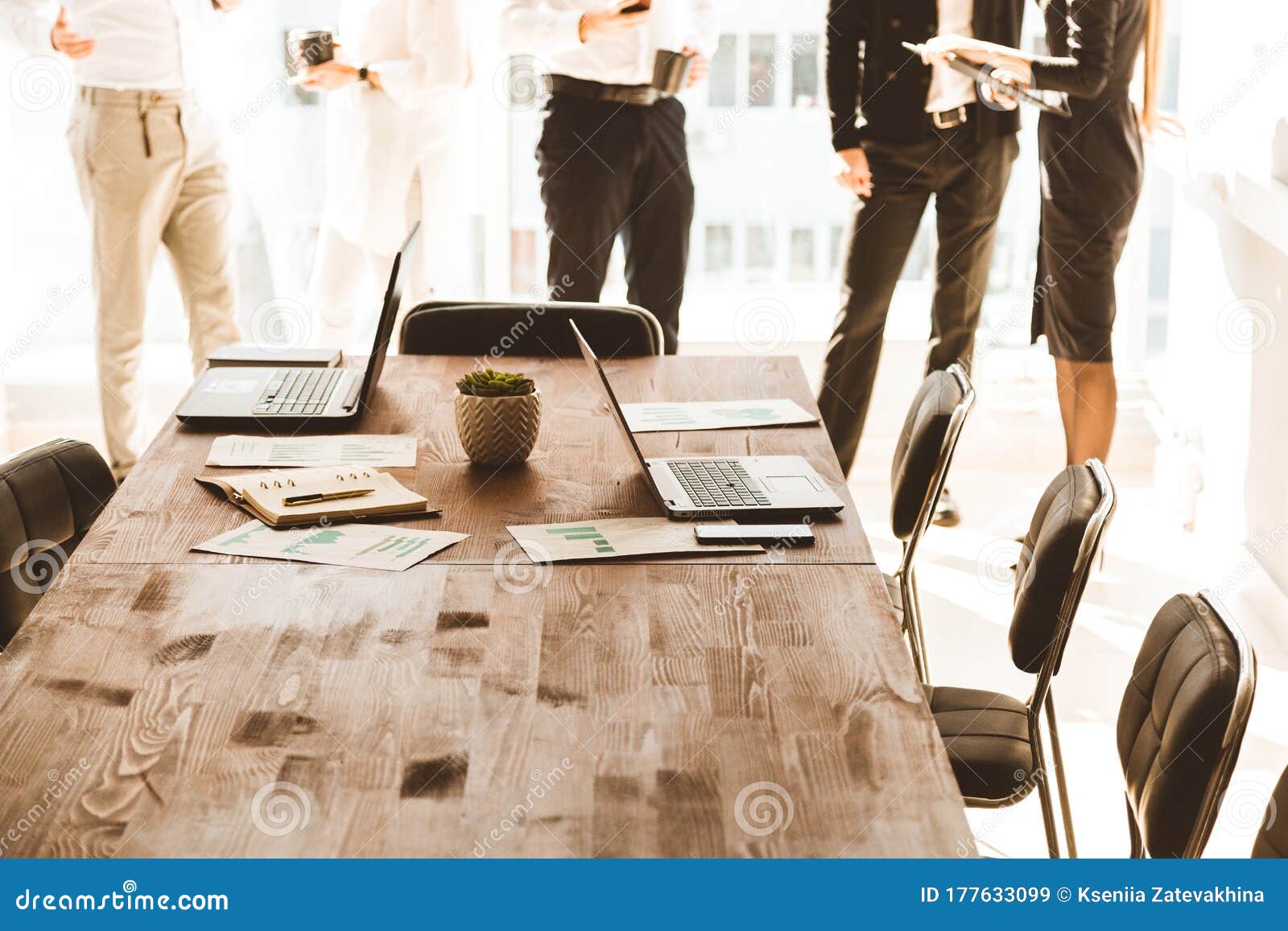 Work Area on the Table in the Foreground. a Team of Young Businessmen ...