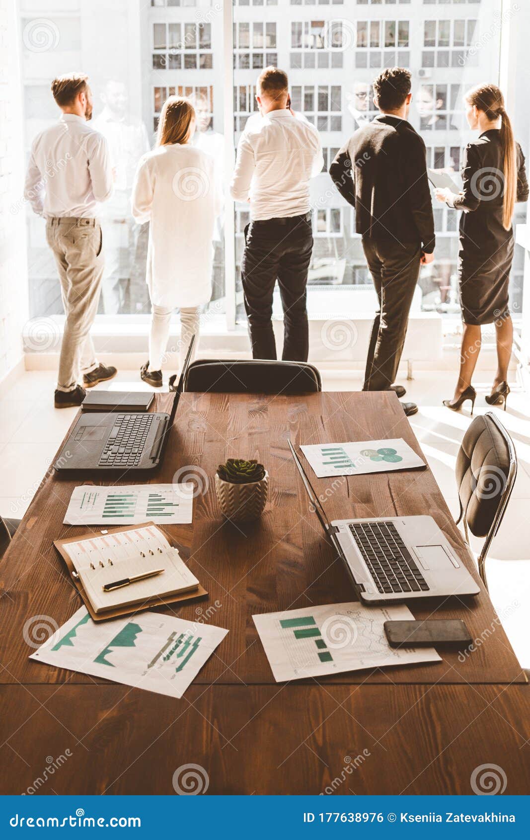 Work Area on the Table in the Foreground. a Team of Young Businessmen ...