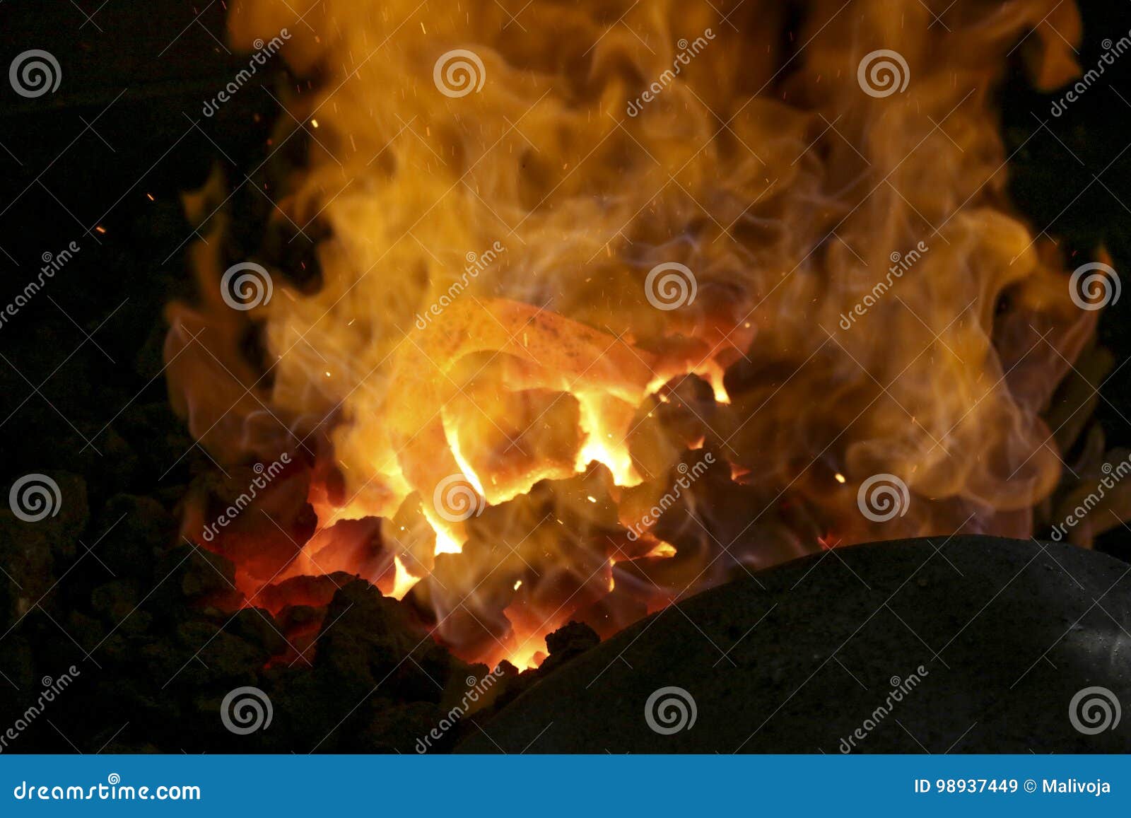 A Blacksmith at Work with Glowing Irons. Hot Iron Forge, a Black Stock ...