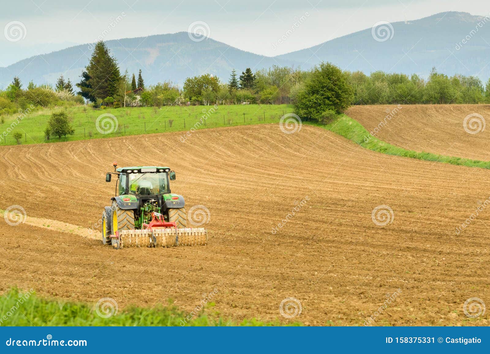 Work in the Field, the Farmer in the Tractor Plows the Field, in the ...