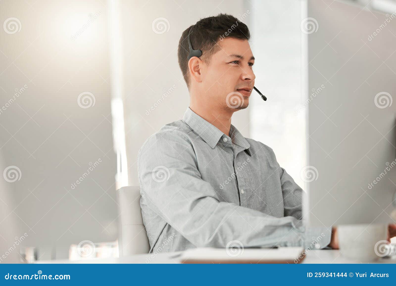 Work Keeps Him Busy All Day. a Young Male Call Center Agent Using a ...