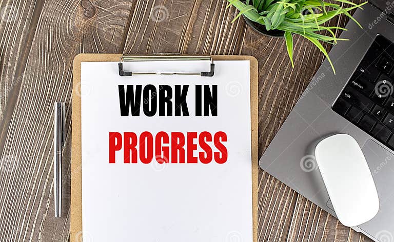 WORK in PROGRESS Text on Clipboard Paper with Laptop, Mouse and Pen ...