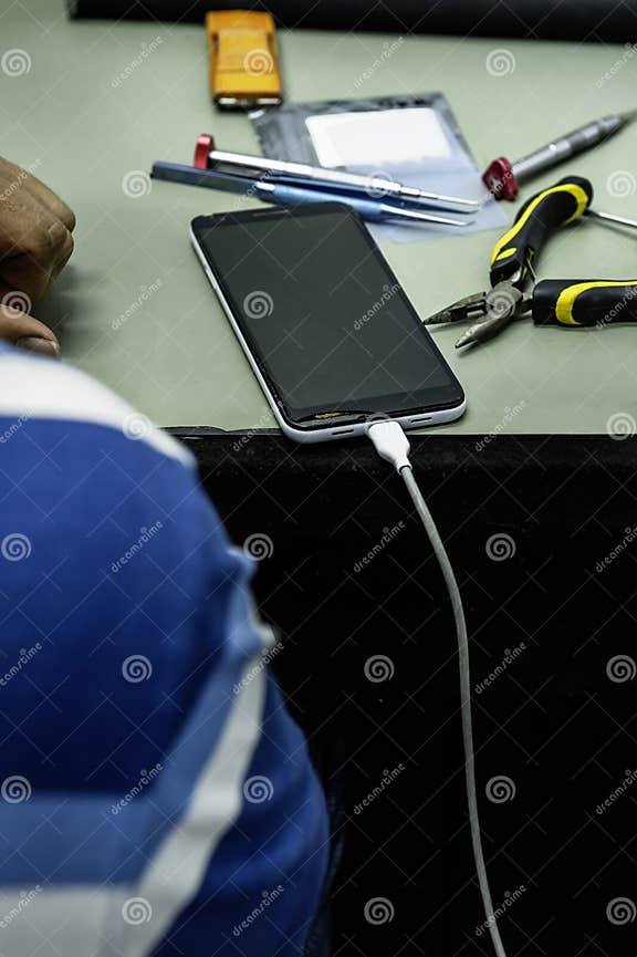 Workbench of a Mobile Phone Repair Technician Working on a Device that ...