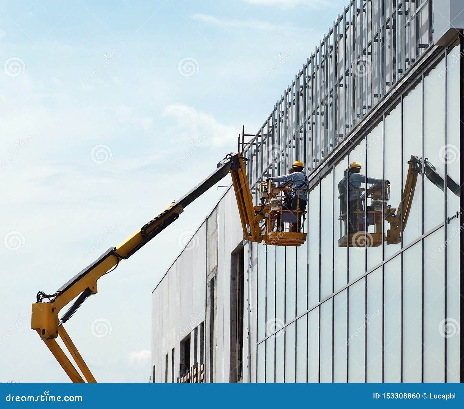 Worker On An Aerial Platform With Their Reflection On The Glass Facade ...
