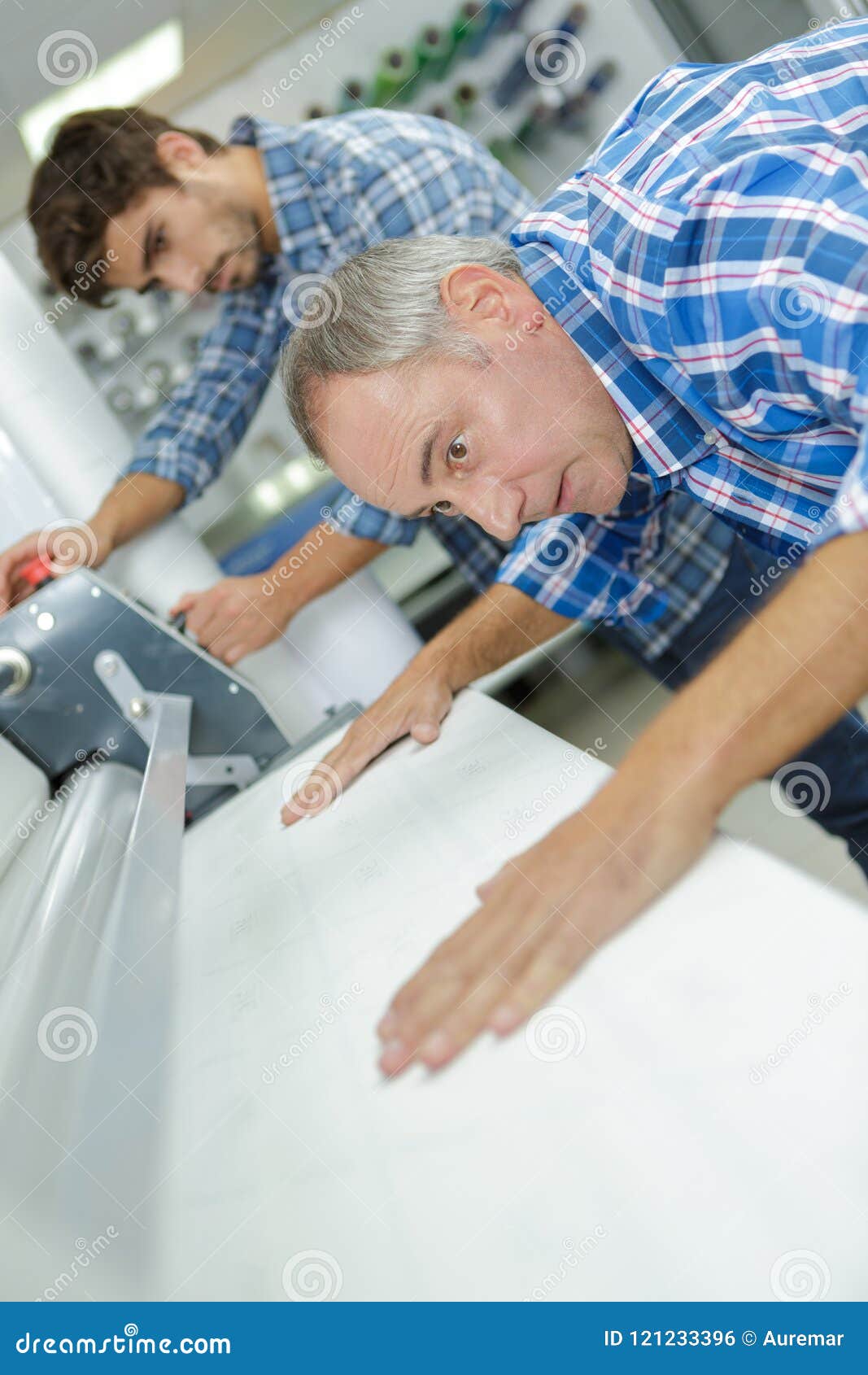 Worker Aligning Material Under Machine Stock Photo - Image of business ...