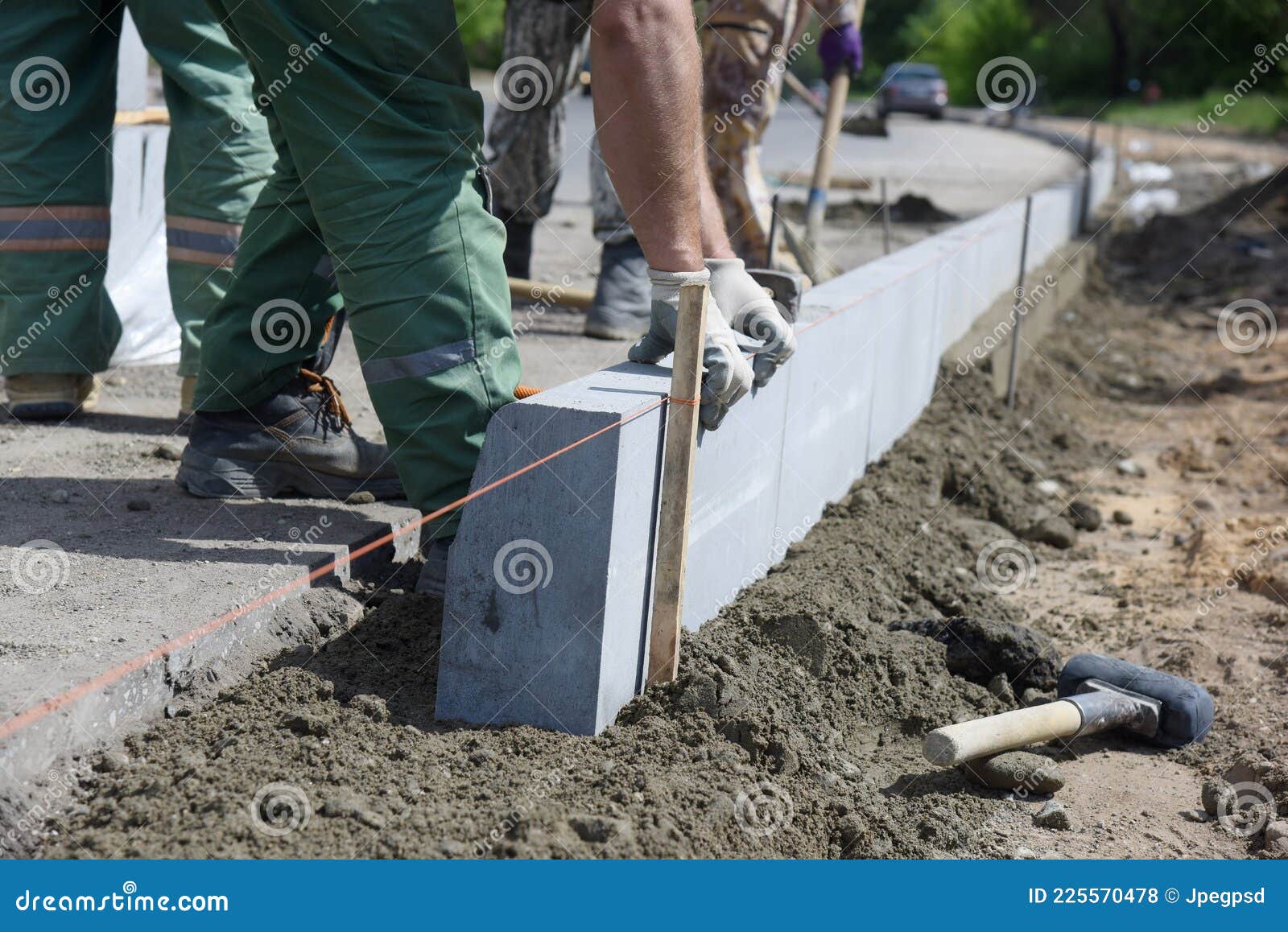 A Worker Aligns a Road Curb in Cement with His Hands. Stock Photo ...