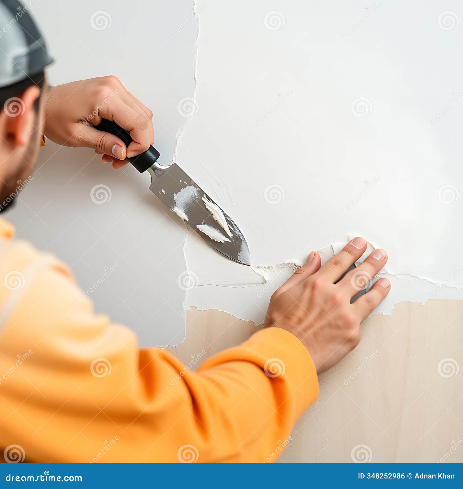 A Worker Applying Joint Compound with a Drywall Taping Knife on a ...