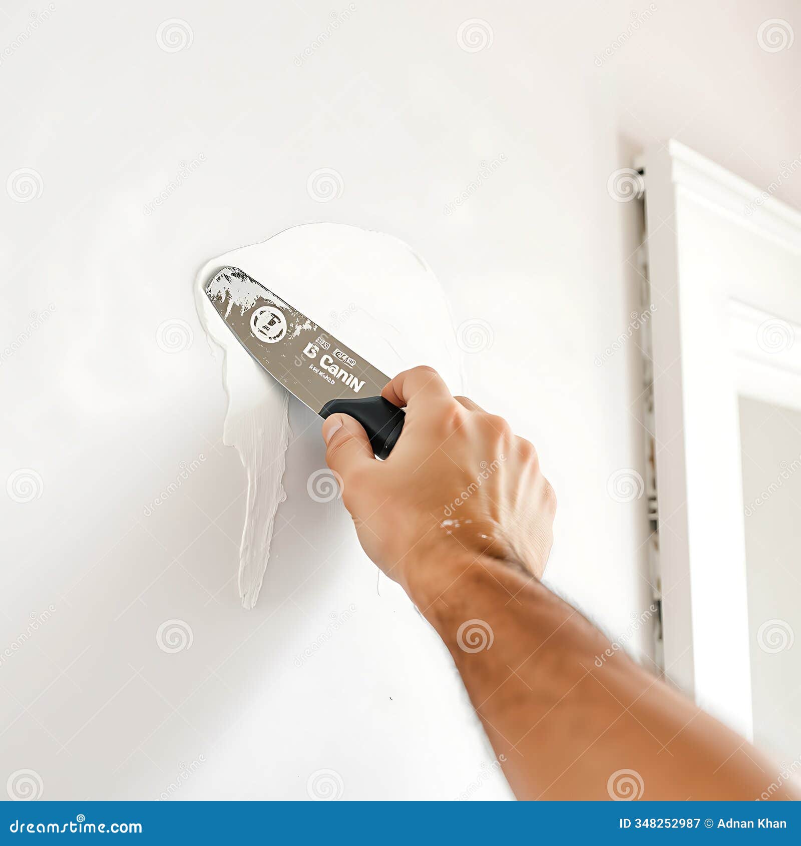 A Worker Applying Joint Compound with a Drywall Taping Knife on a ...
