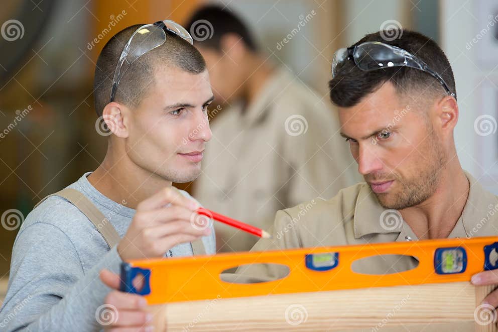 Worker with Apprentice Looking at Level Stock Photo - Image of foreman ...