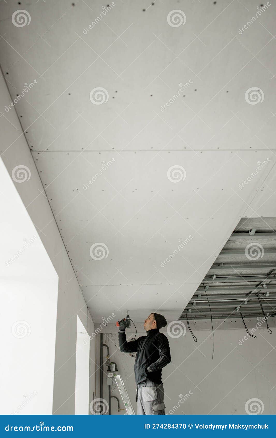 The Worker Attaches Plasterboard on Metal Frame. Installation of ...