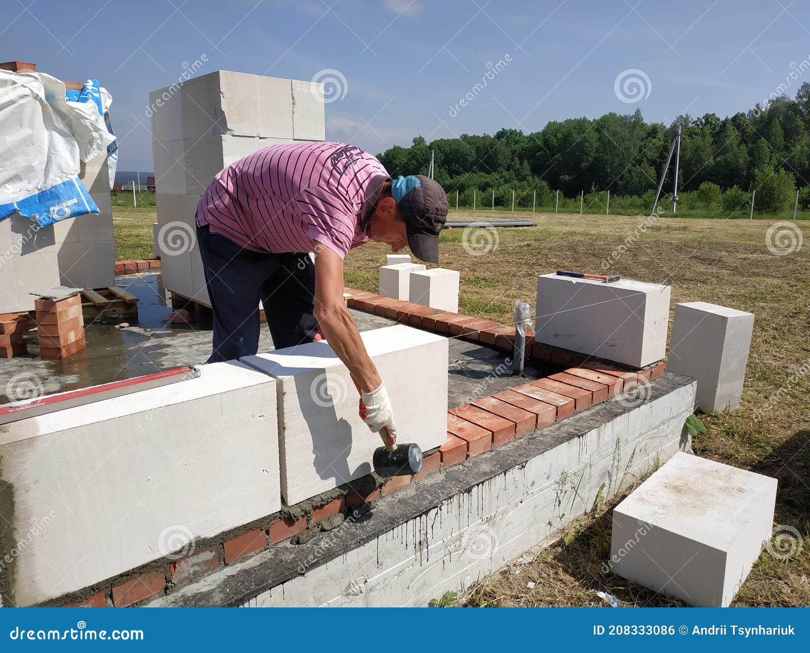 The Worker Begins the First Row of Masonry Construction in White Gas ...