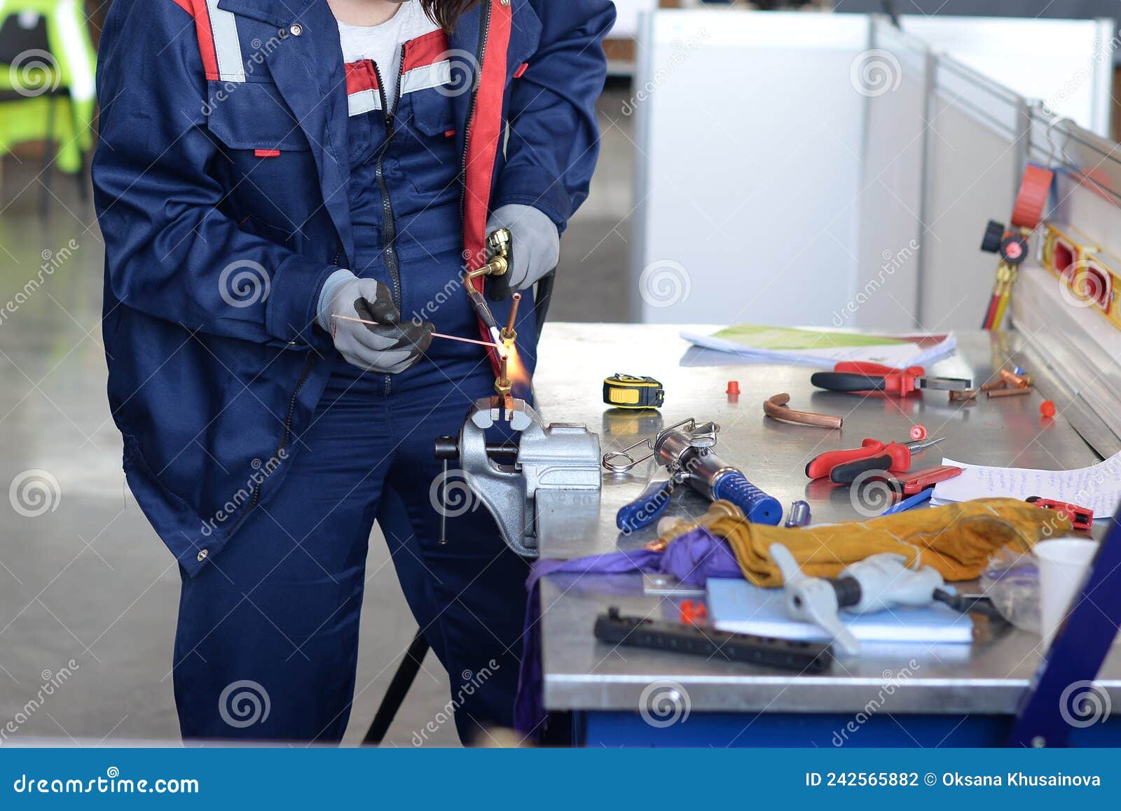 A Worker in a Blue Suit is Welding Products Indoors Stock Photo - Image ...