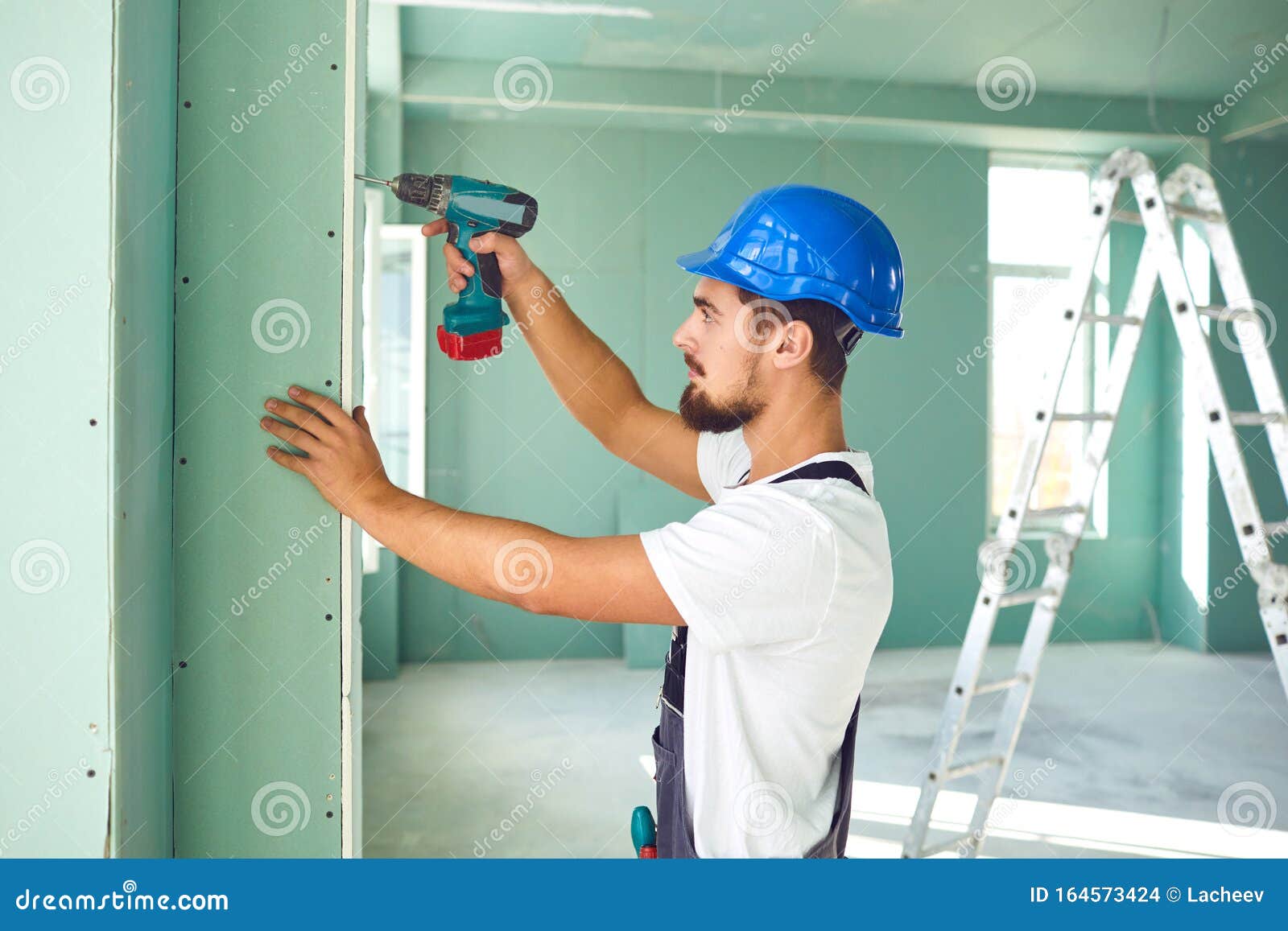 Worker Builder Installs Plasterboard Drywall at a Construction Stock ...