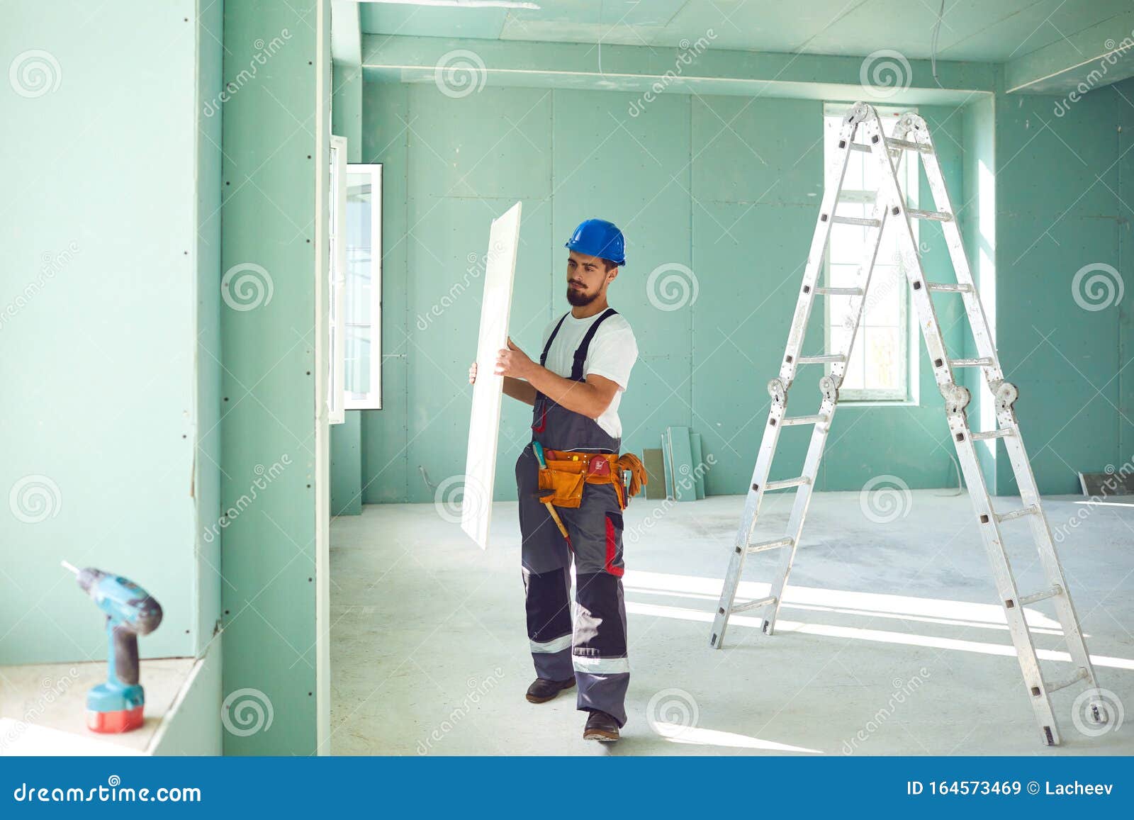 Worker Builder Installs Plasterboard Drywall at a Construction Stock ...