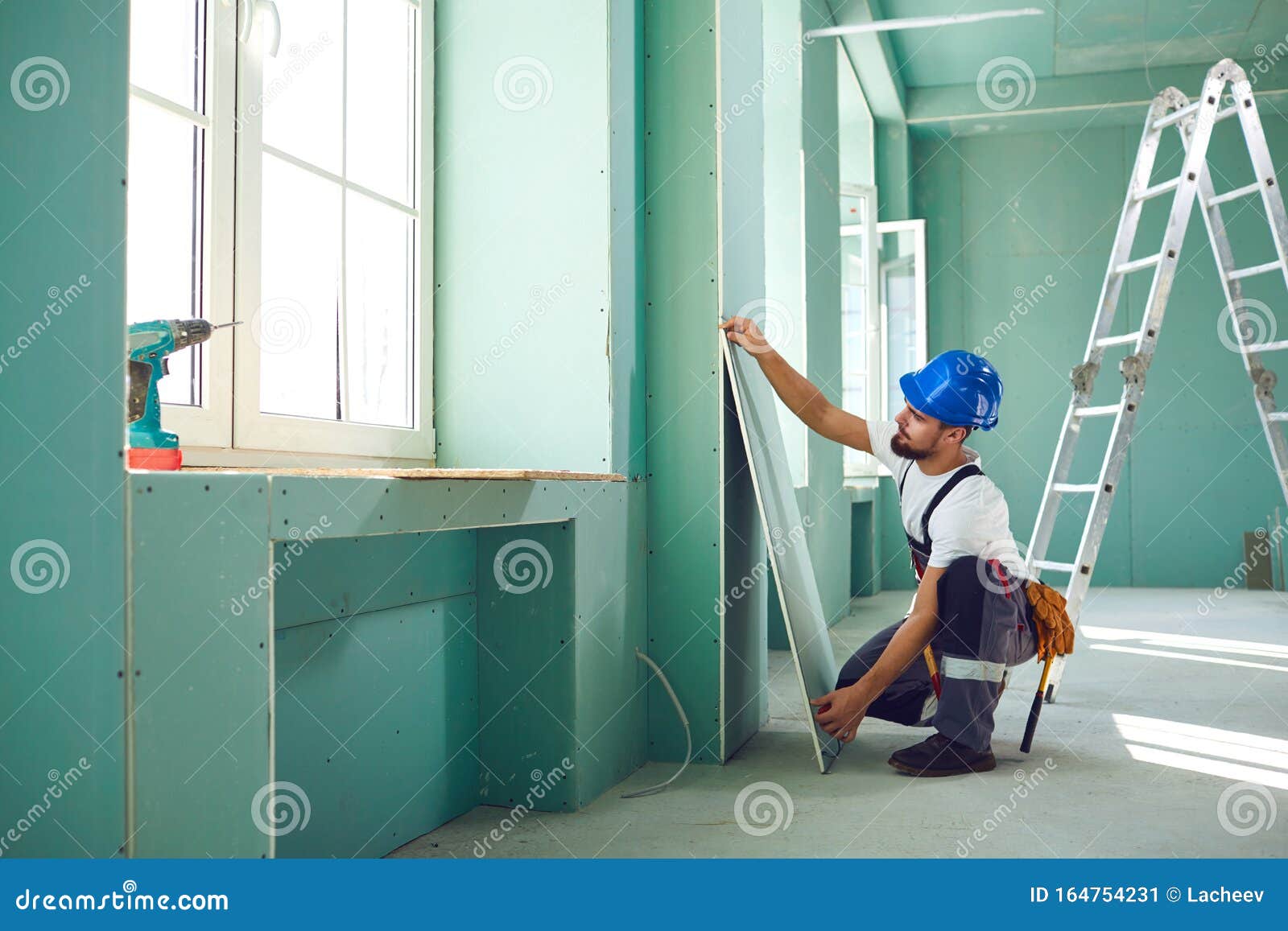 Worker Builder Installs Plasterboard Drywall at a Construction Stock ...