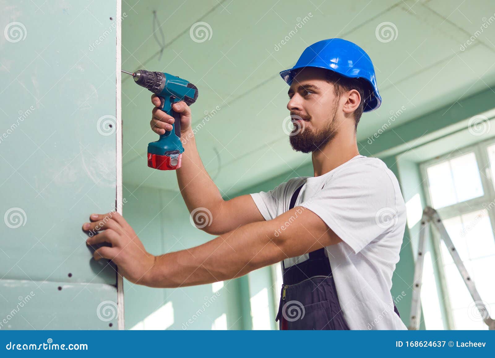 Worker Builder Installs Plasterboard Drywall at a Construction Stock ...