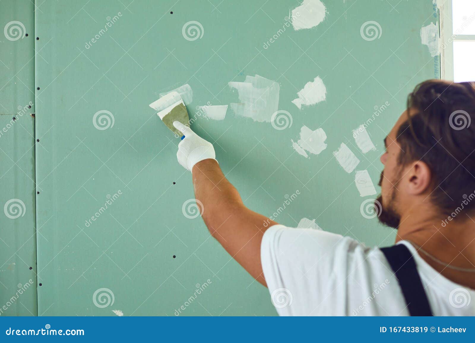 Worker Builder Plasterer Plastering a Wall of Drywall at a Construction ...