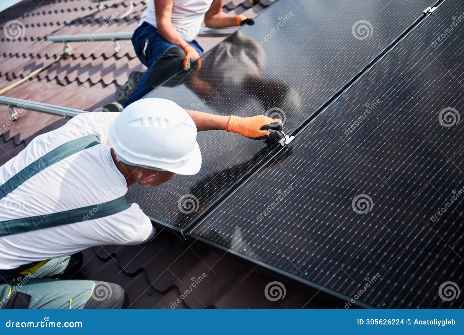 Worker Building Photovoltaic Solar Panel System on Rooftop of House ...