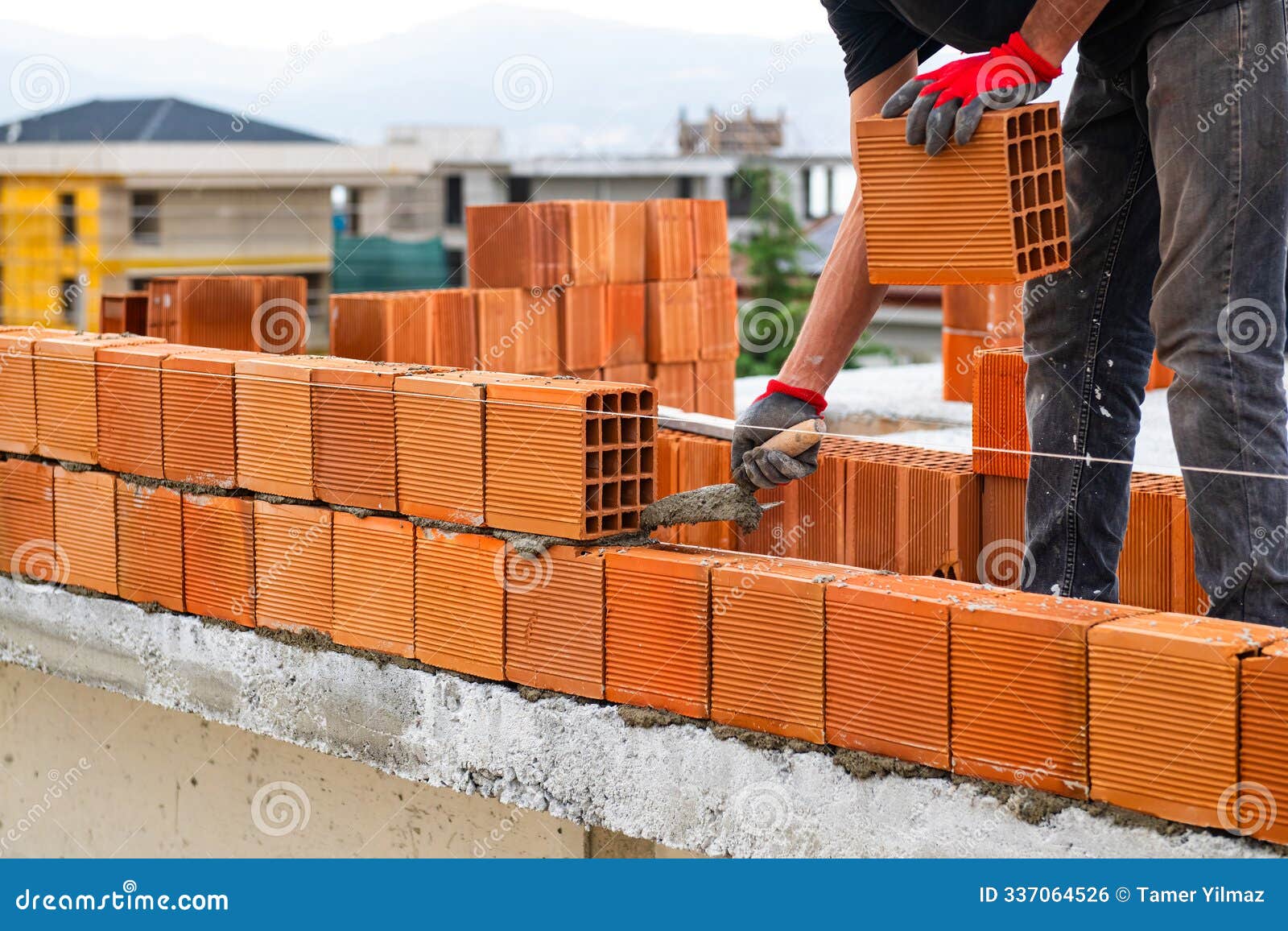 Worker Builds a Brick Wall for House Construction. Worker Building a ...