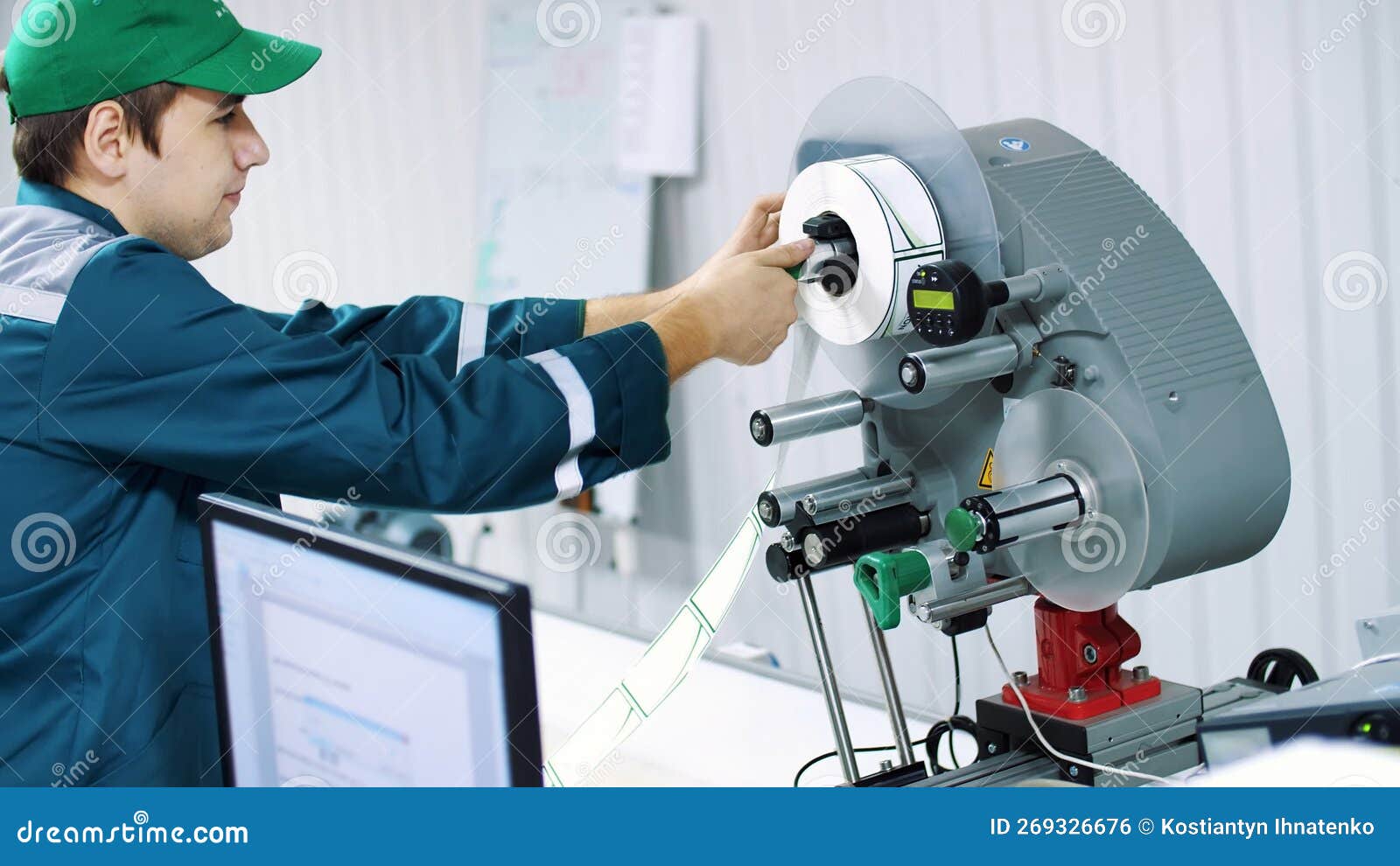The Worker Changes Paper Roll with Marking Stickers on a Machine with ...