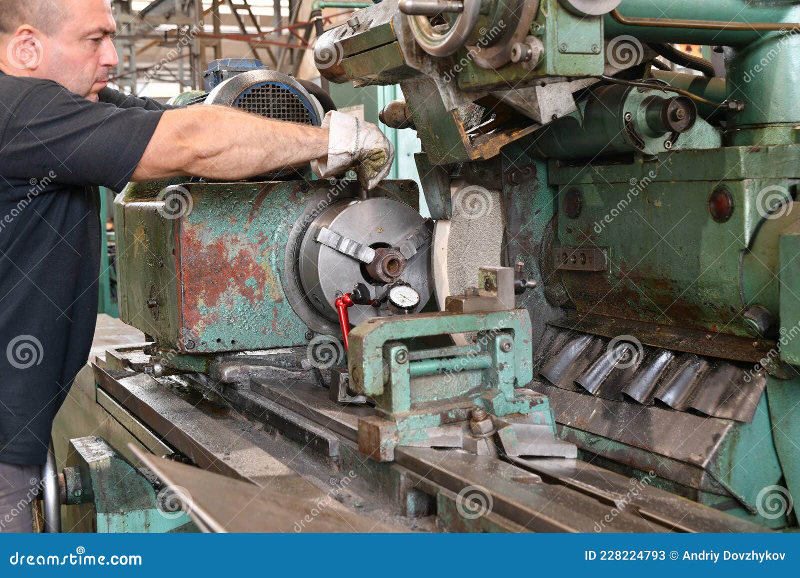 The Worker Clamps the Part in the Chuck of the Grinder for Grinding ...