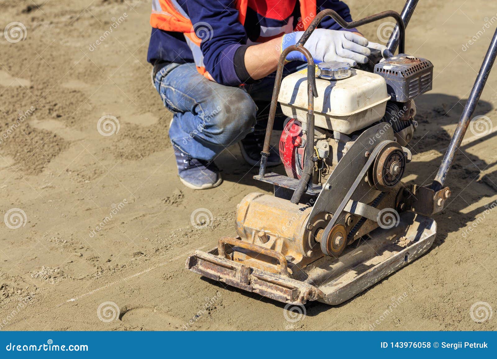 A Worker Cleans an Old Gasoline Compactor To Compact Sandy Soil ...