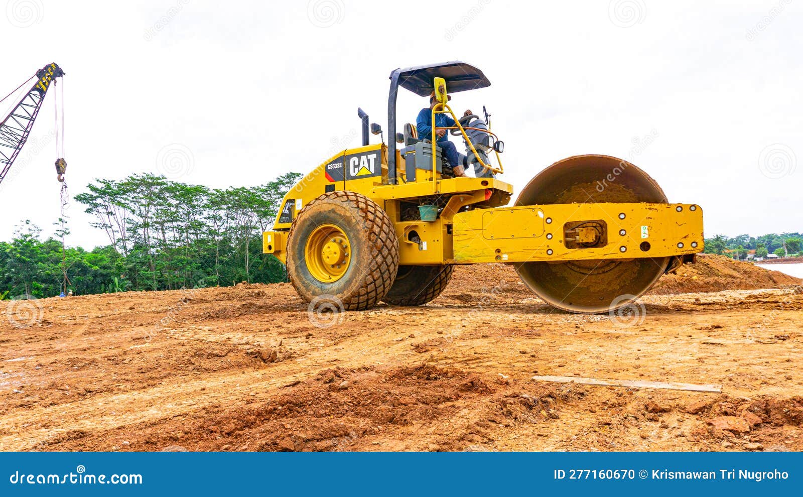 A Worker Compacts Soil Using a Vibration Roller Compactor at a Toll ...