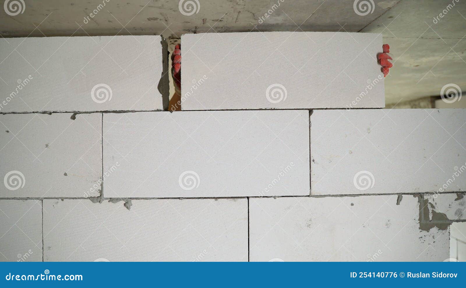 Worker at the Construction Site. Professional Builder Laying Blocks ...