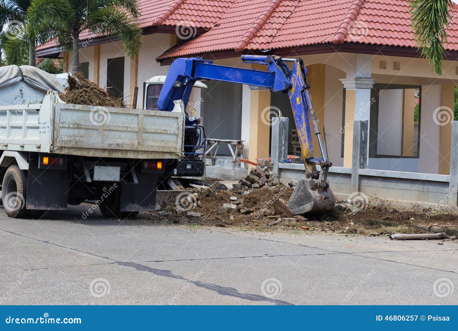 The Worker Controls the Backhoe Shovel To Load the Earth on the Stock ...