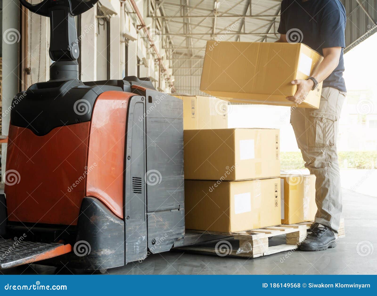 Worker Courier Lifting Shipments Boxes at the Warehouse. Stock Photo ...