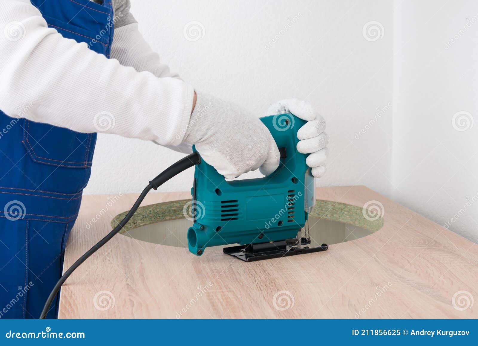 The Worker Cuts a Hole in the Countertop with a Jigsaw for Installing a ...