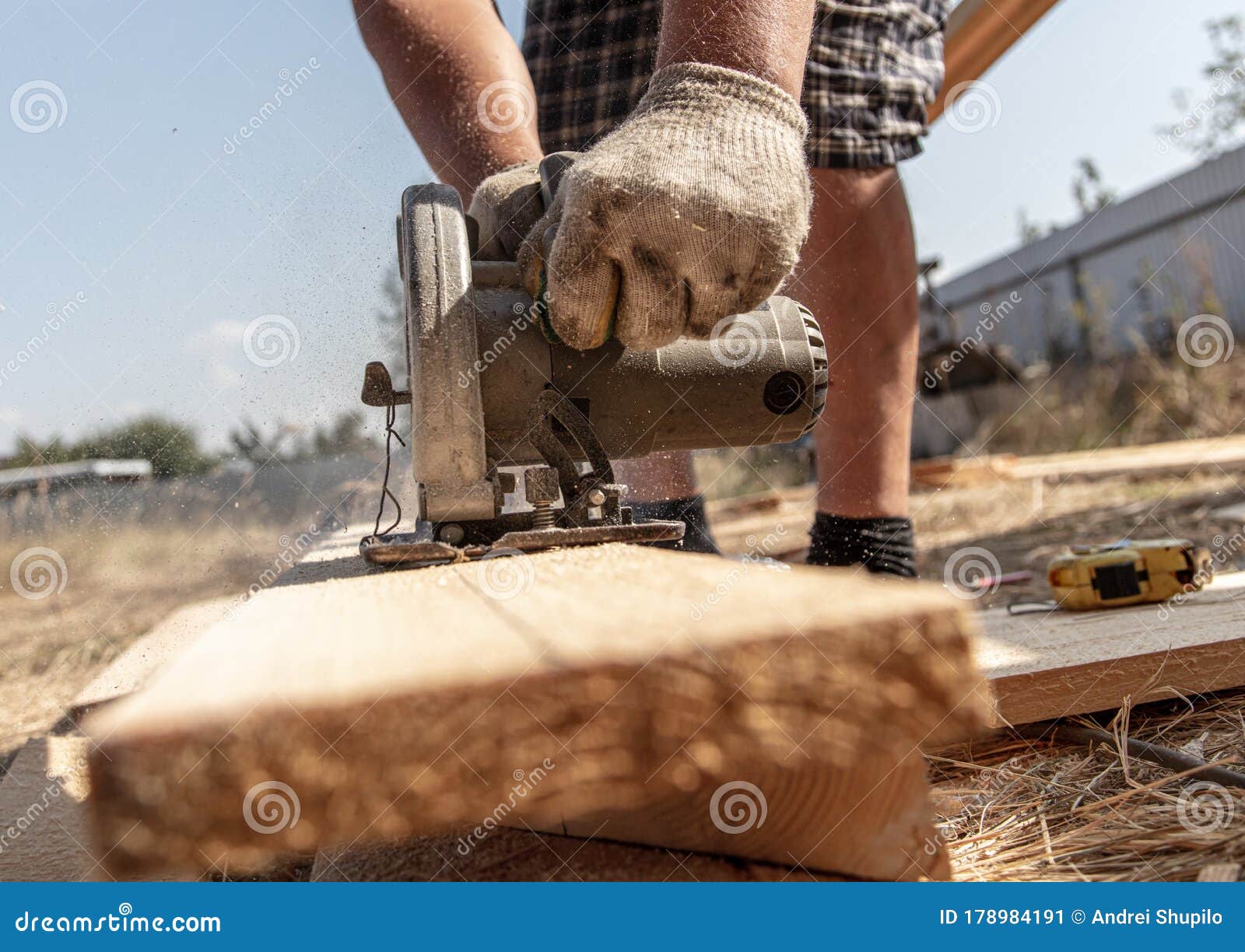 A Worker Cuts a Wooden Board at a Construction Site Stock Image - Image ...
