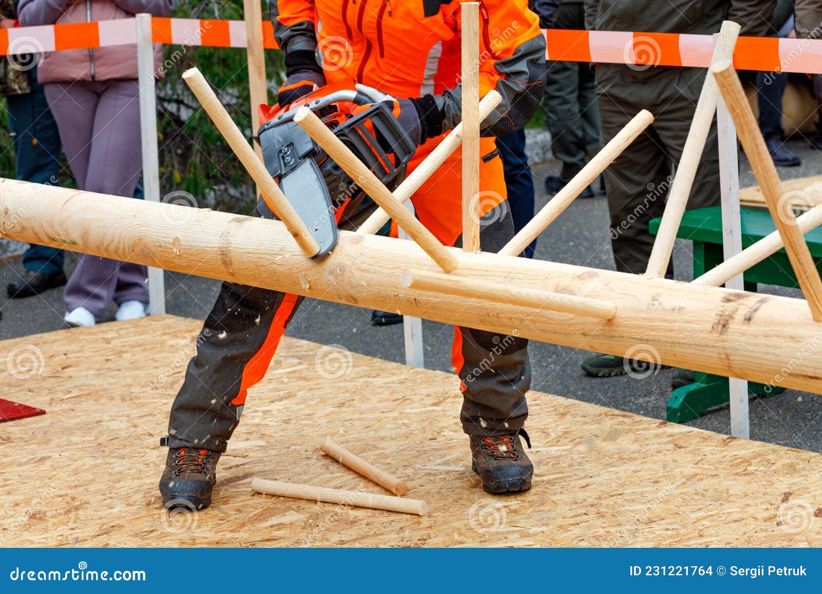 A Worker Demonstrates the Skill of Using a Chainsaw at the Working Site ...