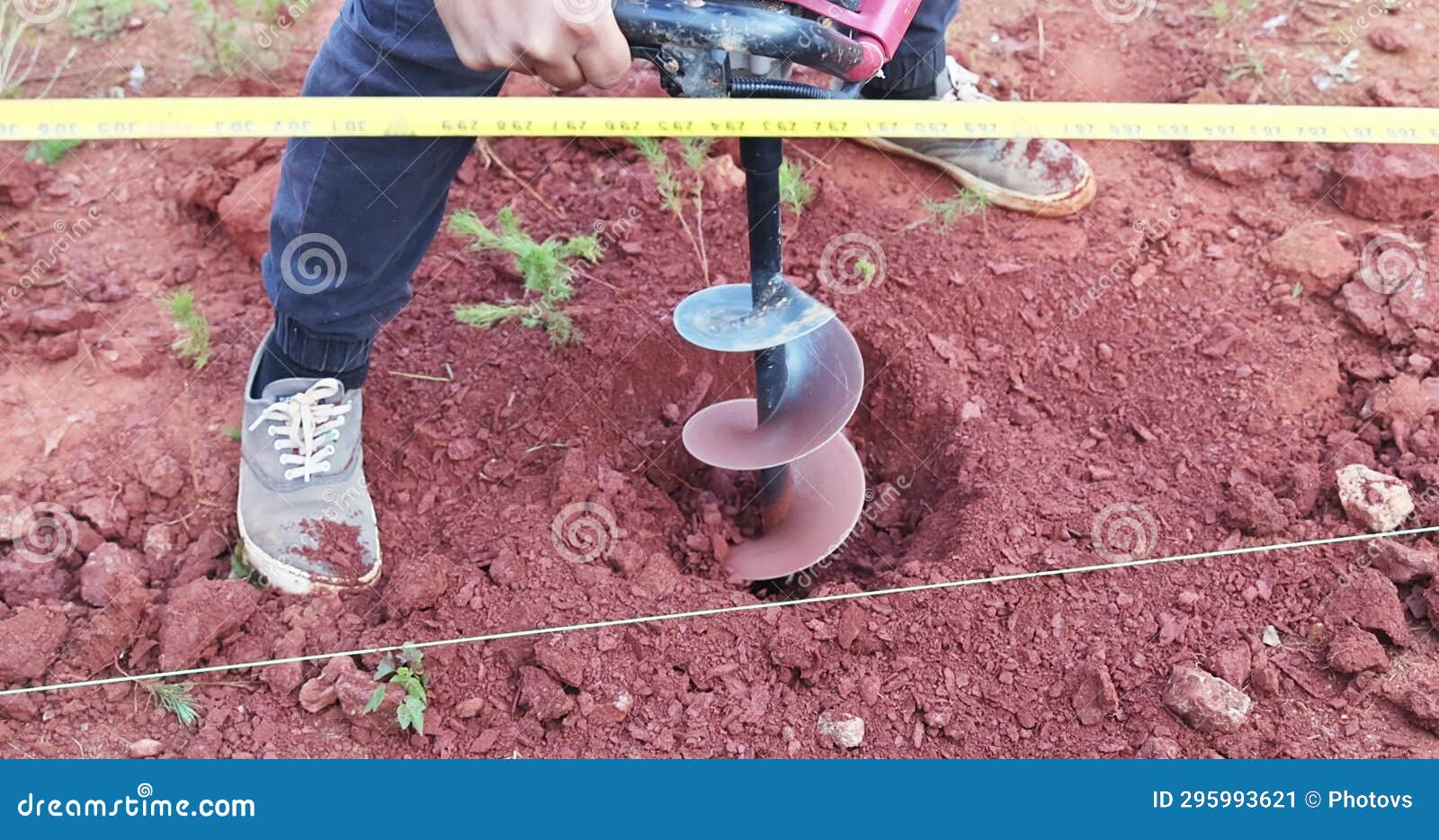 Worker Digs Ground for Fencing Posts Using a Gasoline Powered Drilling ...