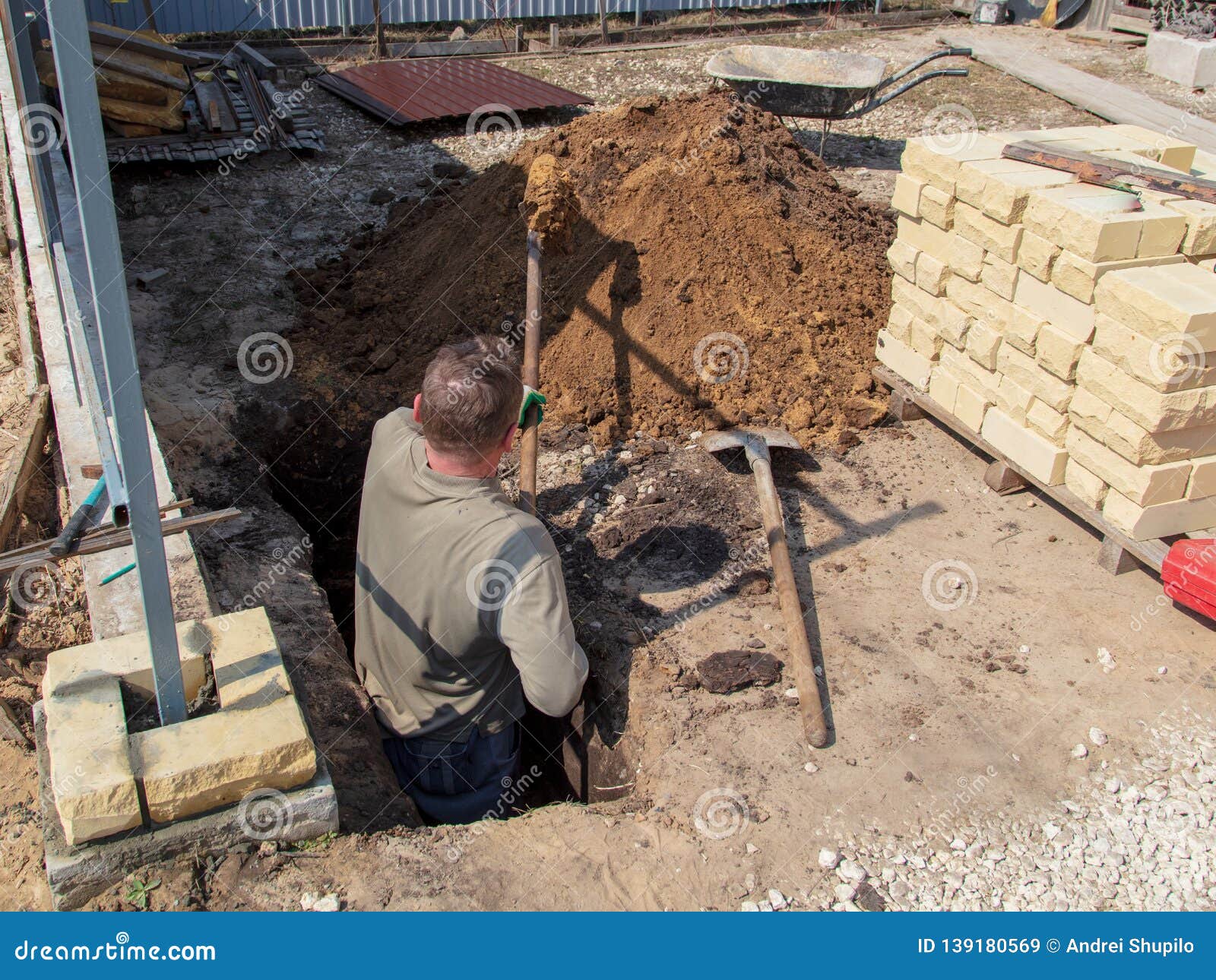 A Worker Digs a Pit with a Shovel on a Construction Site Editorial ...