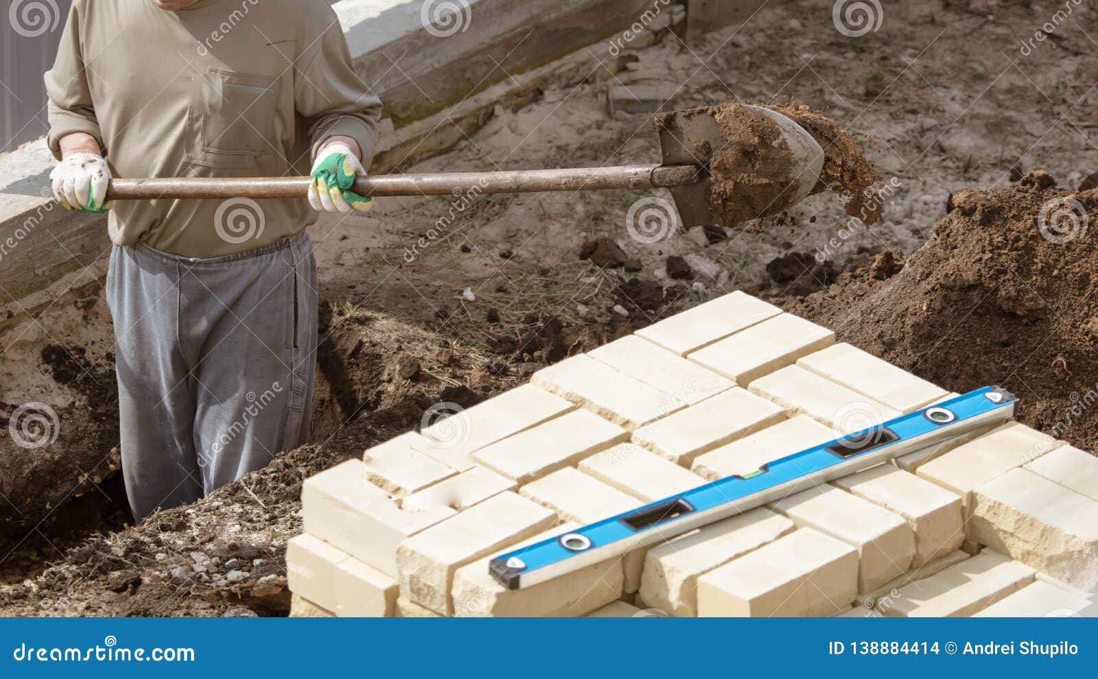A Worker Digs a Pit with a Shovel on a Construction Site Stock Photo ...