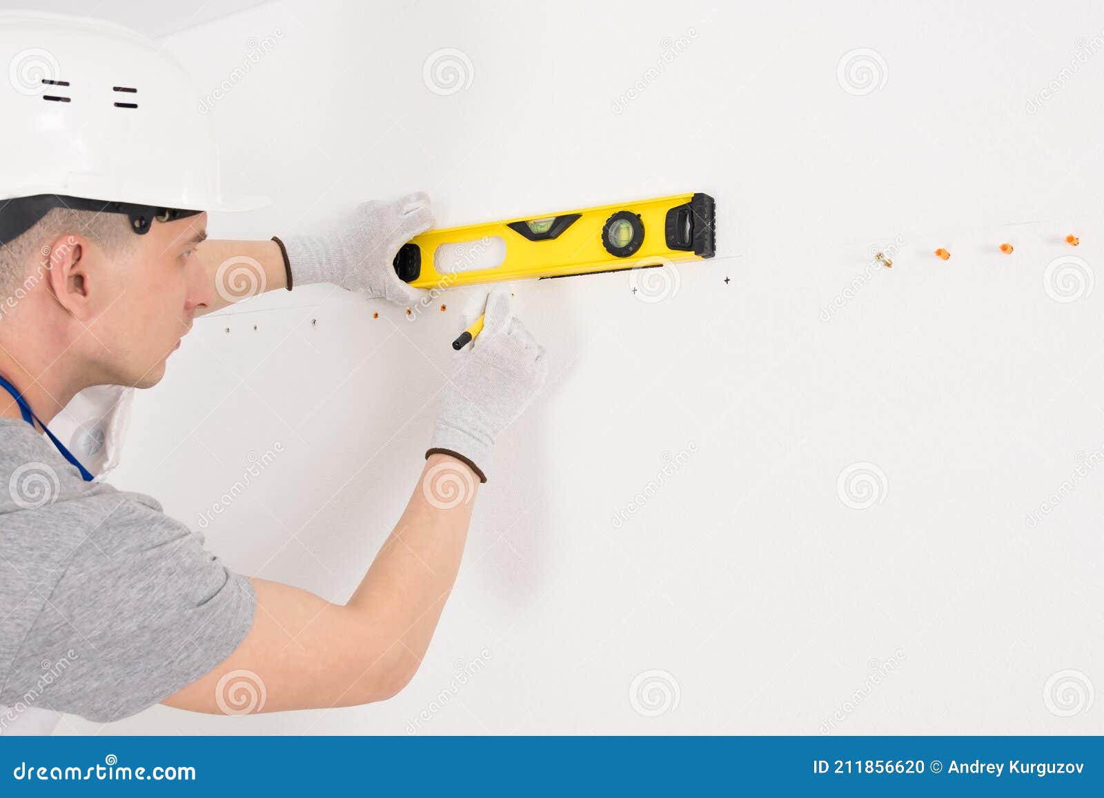 A Worker Draws a Straight Line Using a Tool - Level on a White Wall ...