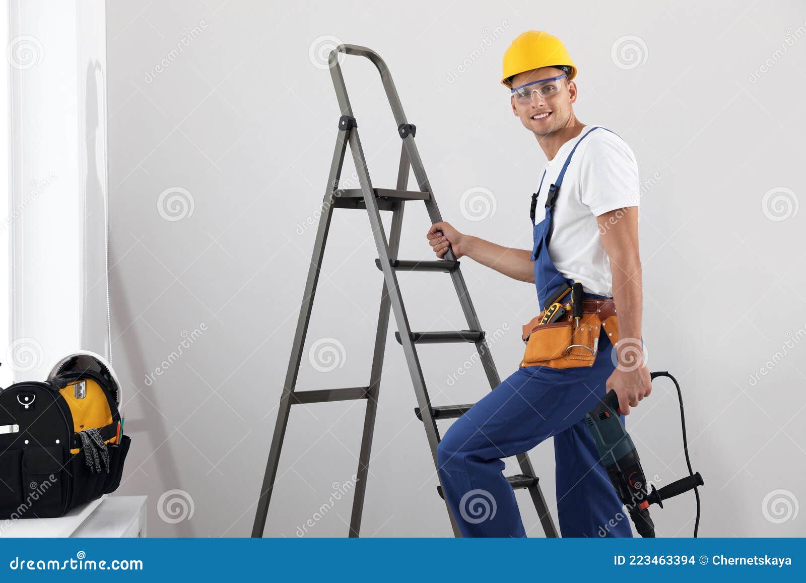 Worker with Electric Drill on Ladder Indoors Stock Photo - Image of ...