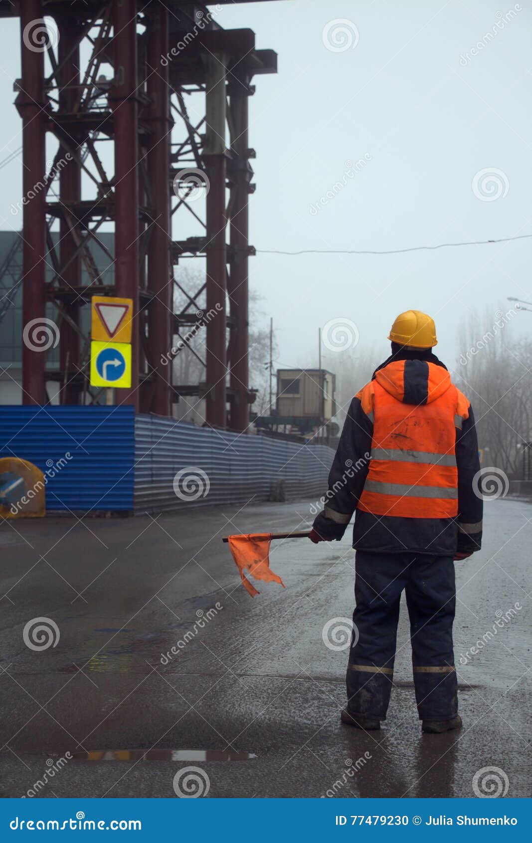 Worker With Flag Standing Across The Road Preventing Traffic In ...