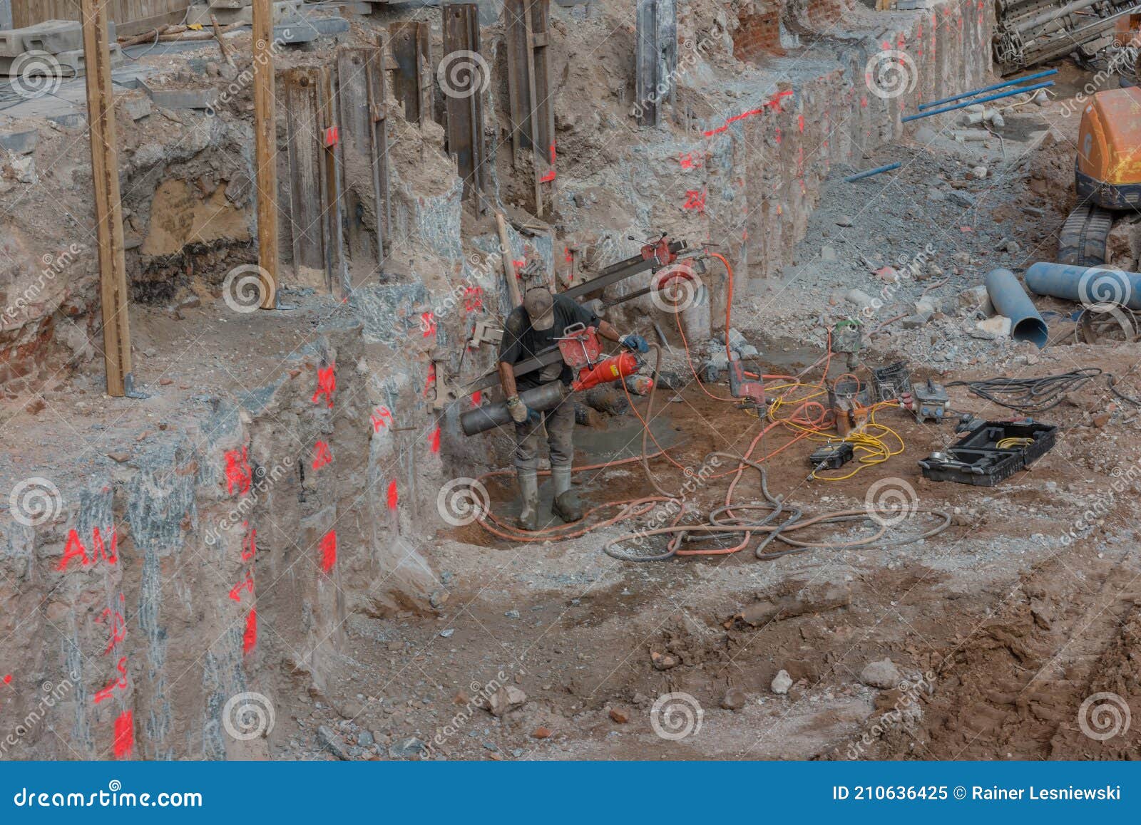 Worker in the Foundation Trench with Construction Machinery on the ...