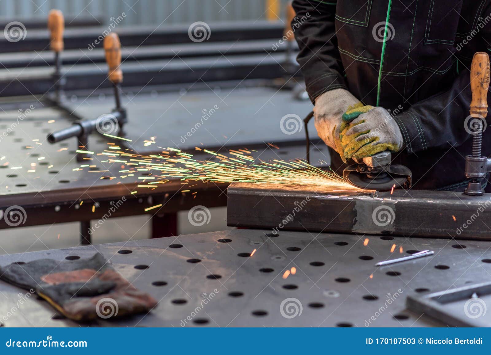 Worker Grinding the Junction between Two Sections of a Metal Square ...