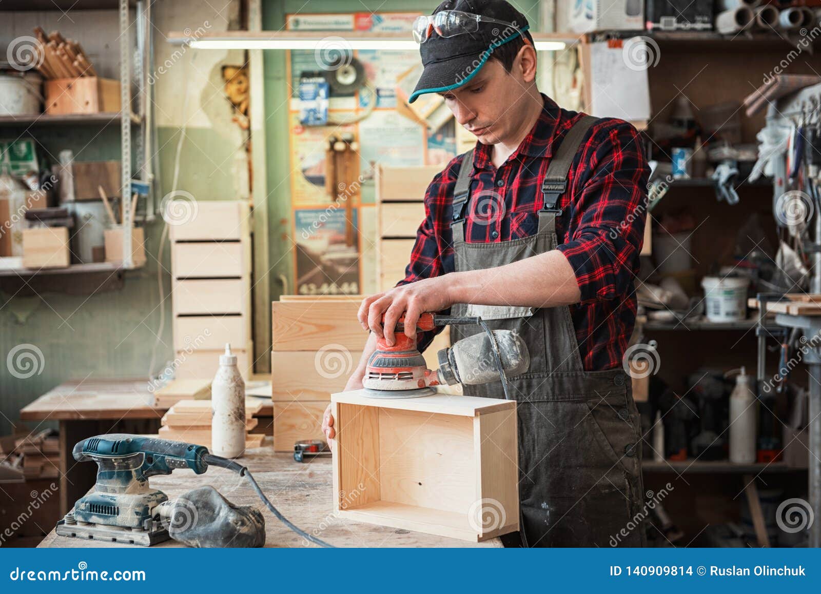 Worker grinds the wood box stock photo. Image of male - 140909814