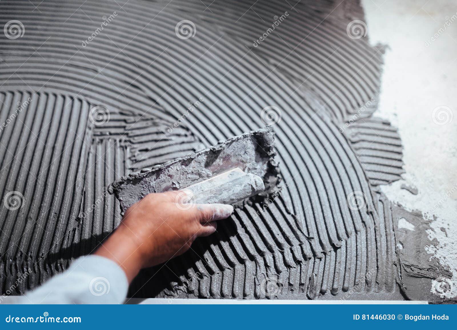 Worker Hand Plastering a Wall, Adding Adhesive with Comb Trowel Stock ...