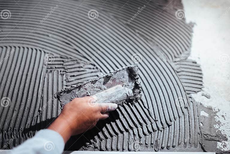 Worker Hand Plastering a Wall, Adding Adhesive with Comb Trowel Stock ...